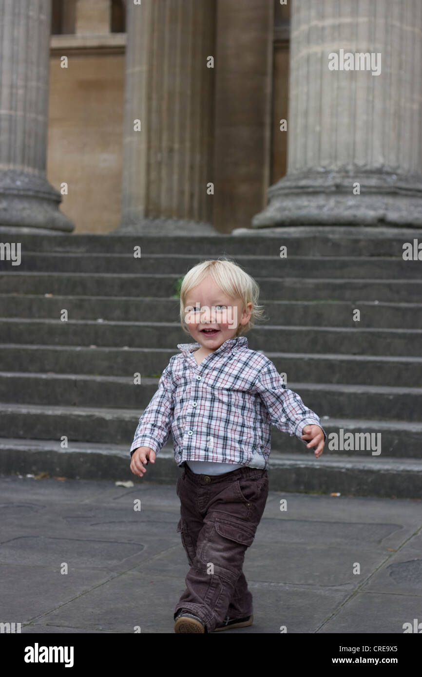 Blond boy taking steps and smiling Stock Photo - Alamy