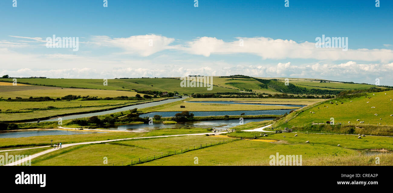A view of the Cuckmere Estuary on a summers day with blue sky and white ...