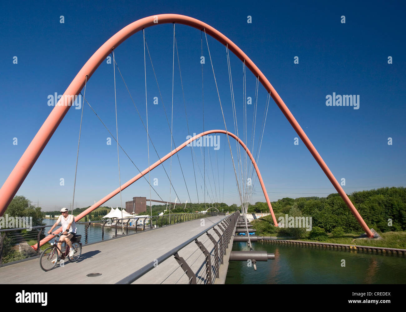 cyclist on the red steel arch bridge over the Rhine-Herne-Channel at ...