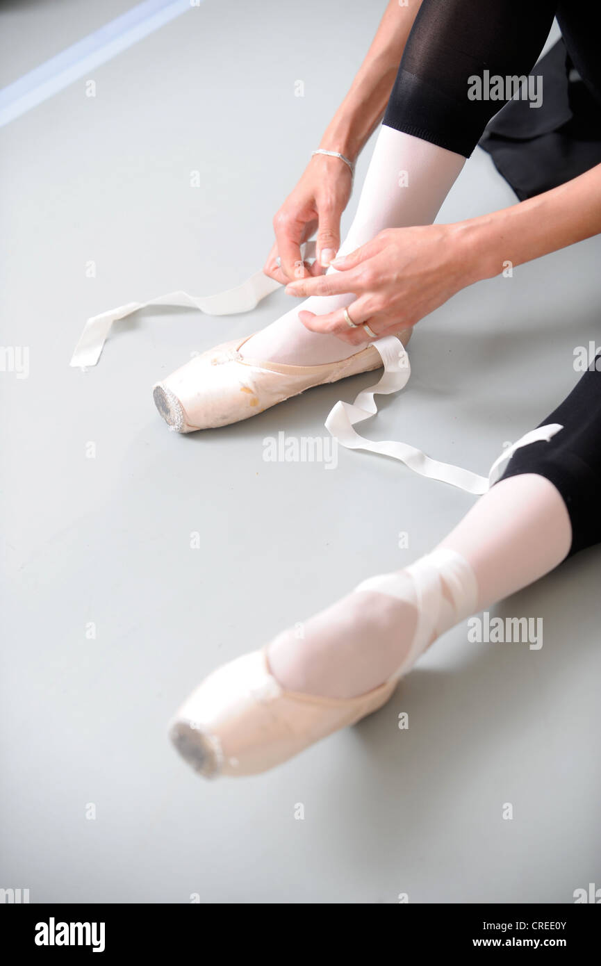A ballet dancer loosens the ribbons on her shoes Stock Photo - Alamy