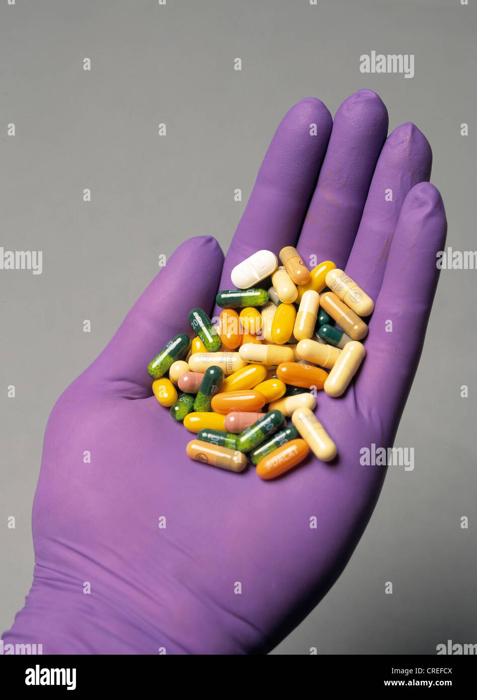Tablets in a hand that wears a colored surgical gloves Stock Photo - Alamy