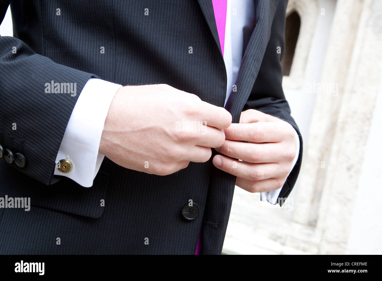 Bridegroom buttoning up his jacket Stock Photo - Alamy