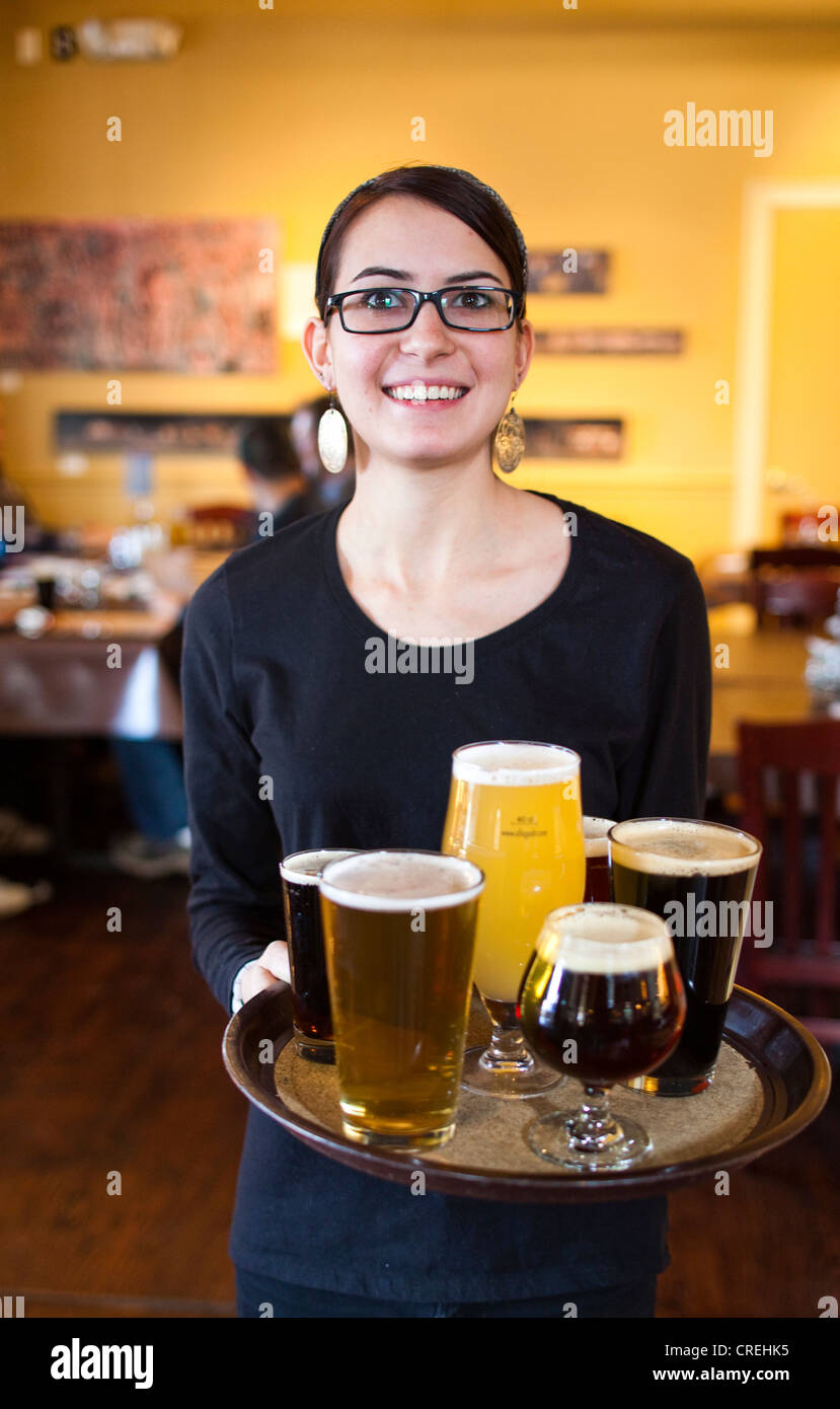 A female server holds a tray full of beer Stock Photo - Alamy