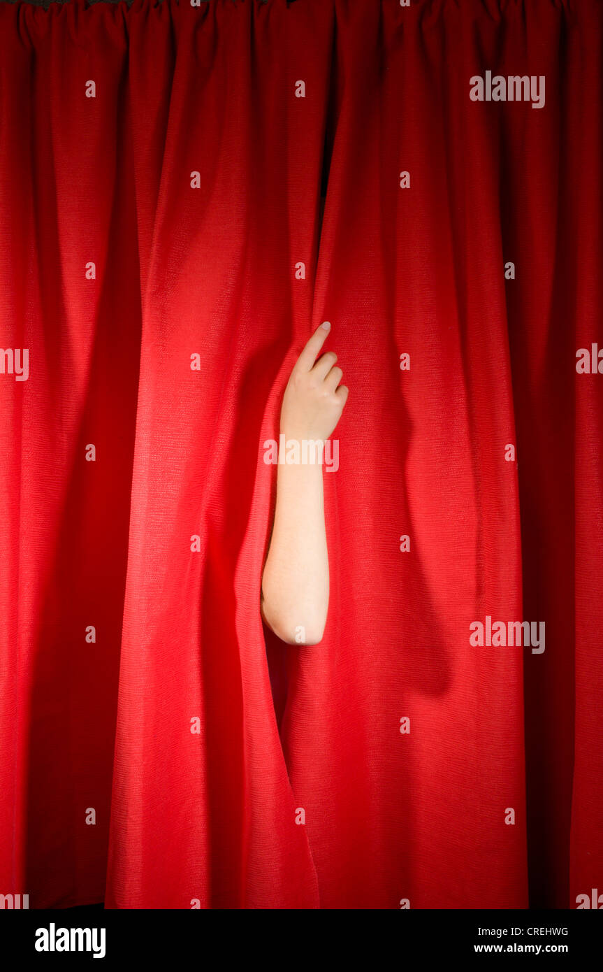 Arm reaching through red curtains Stock Photo - Alamy