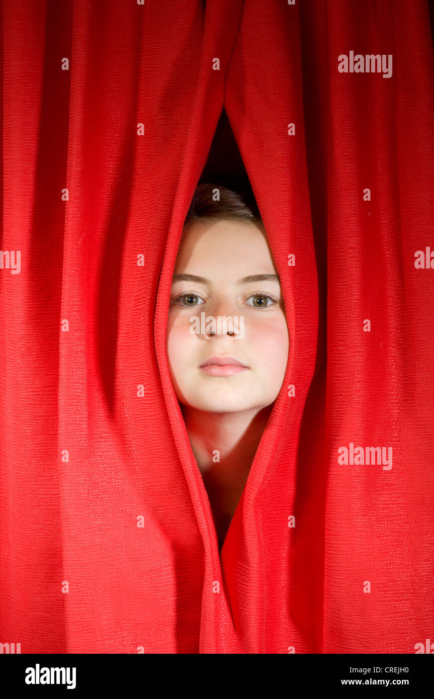 Red curtains on stage with face peering through Stock Photo - Alamy