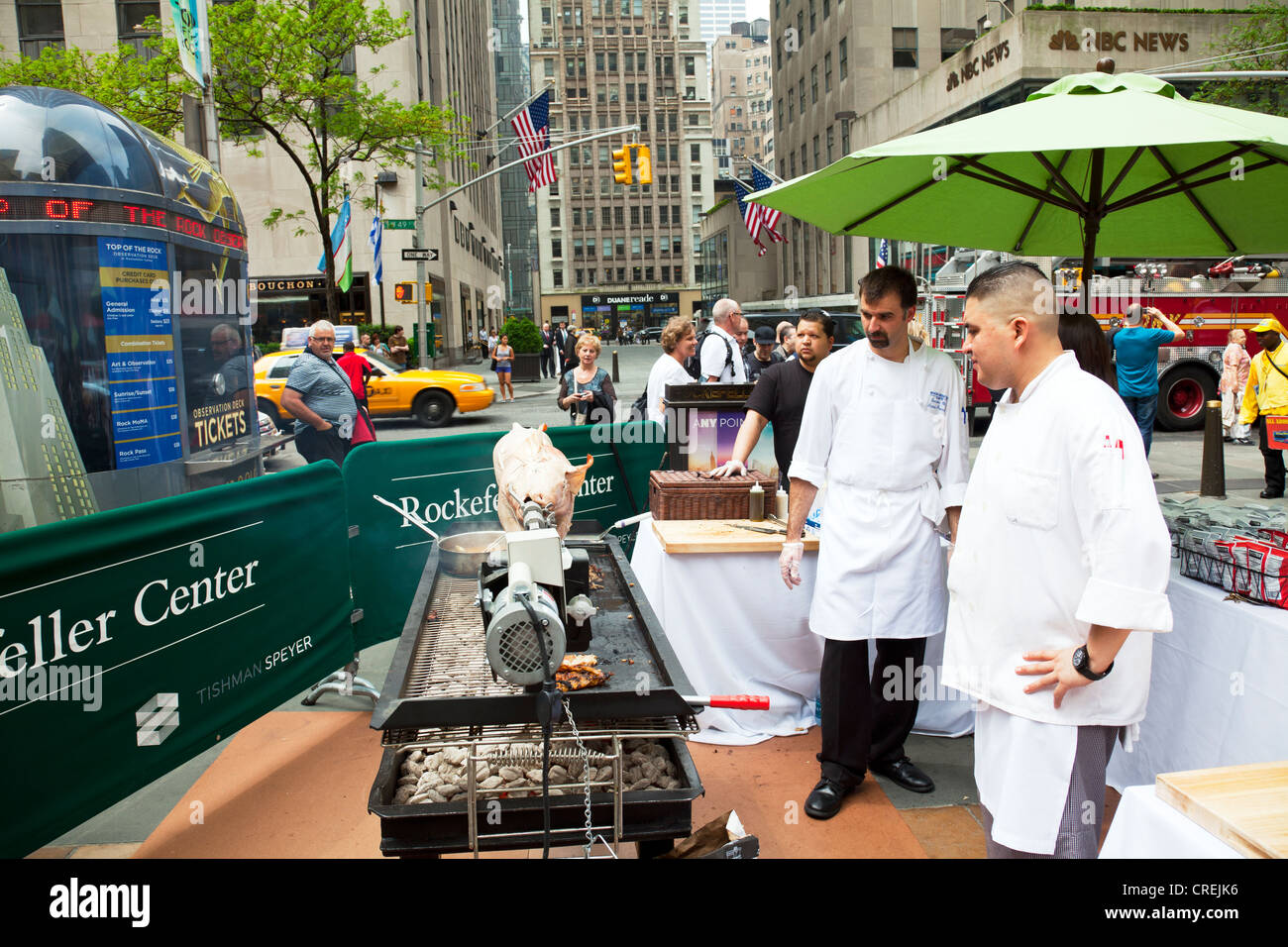 New York City, Manhattan street party. Chefs spit roasting a whole pig ...