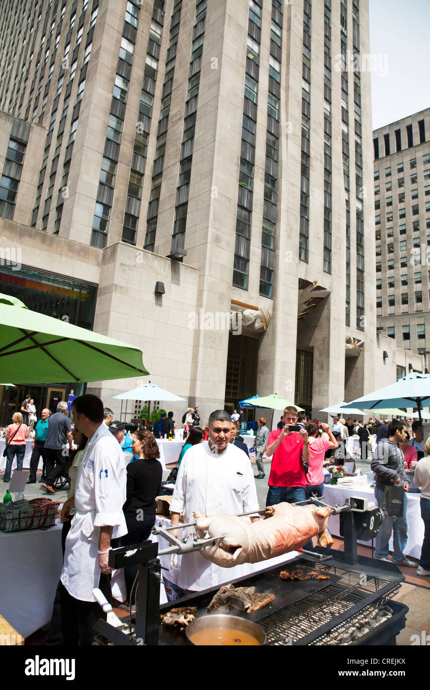 New York City, Manhattan street party. Chefs spit roasting a whole pig ...