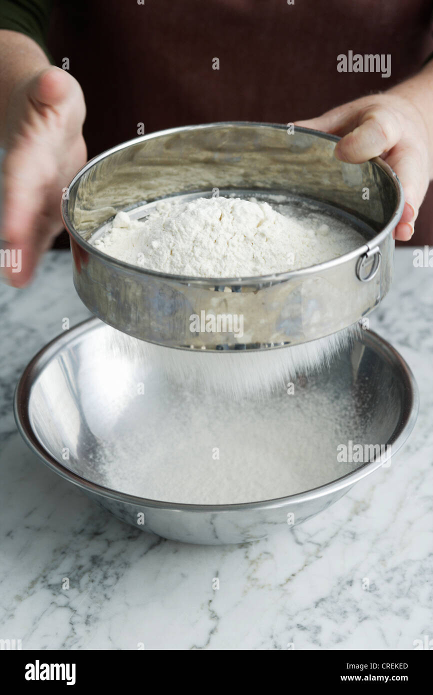 Chef sifting flour in bowl Stock Photo - Alamy