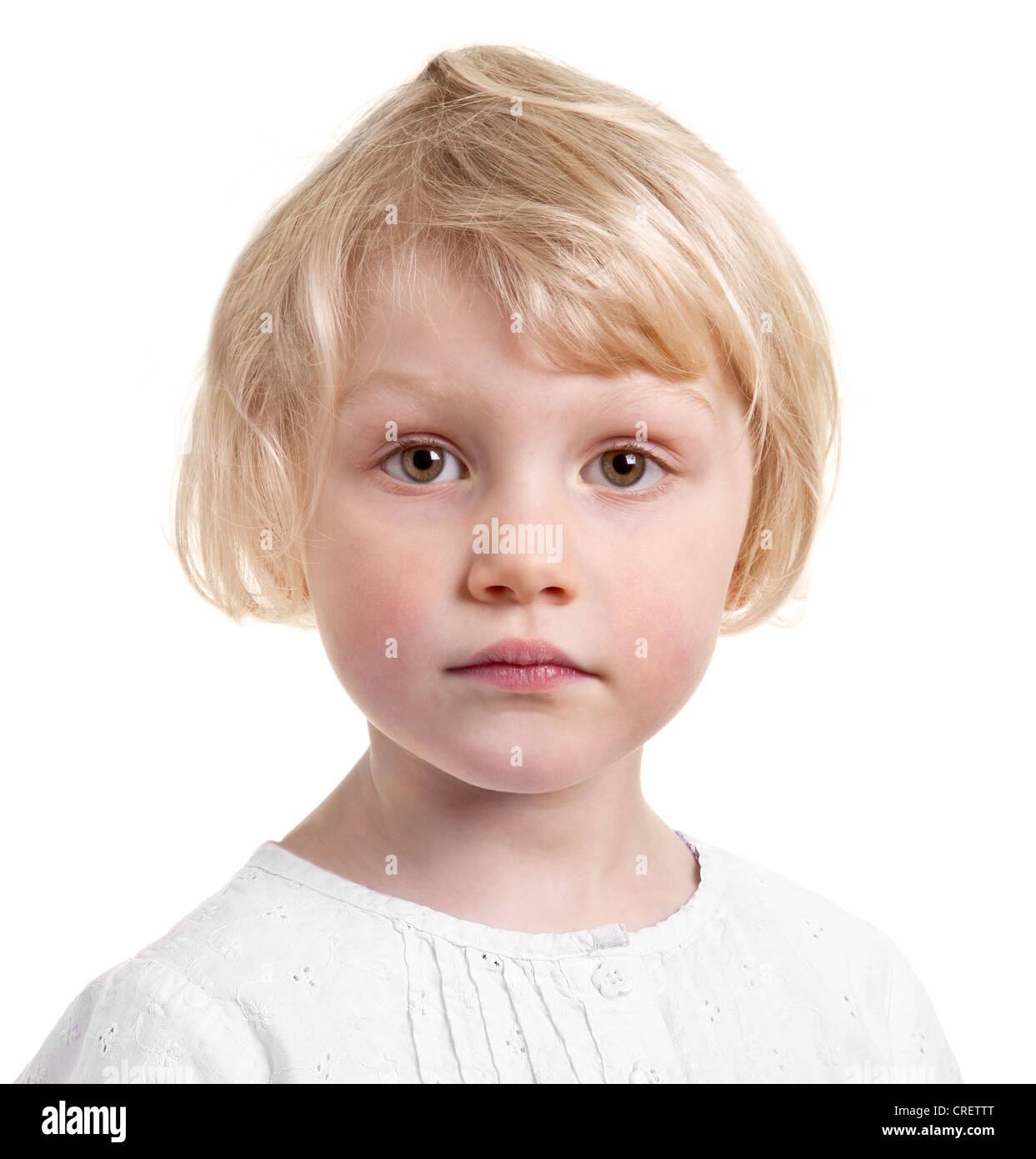 Portrait of a moody, pretty, blonde, 4 year old girl in a white dress ...
