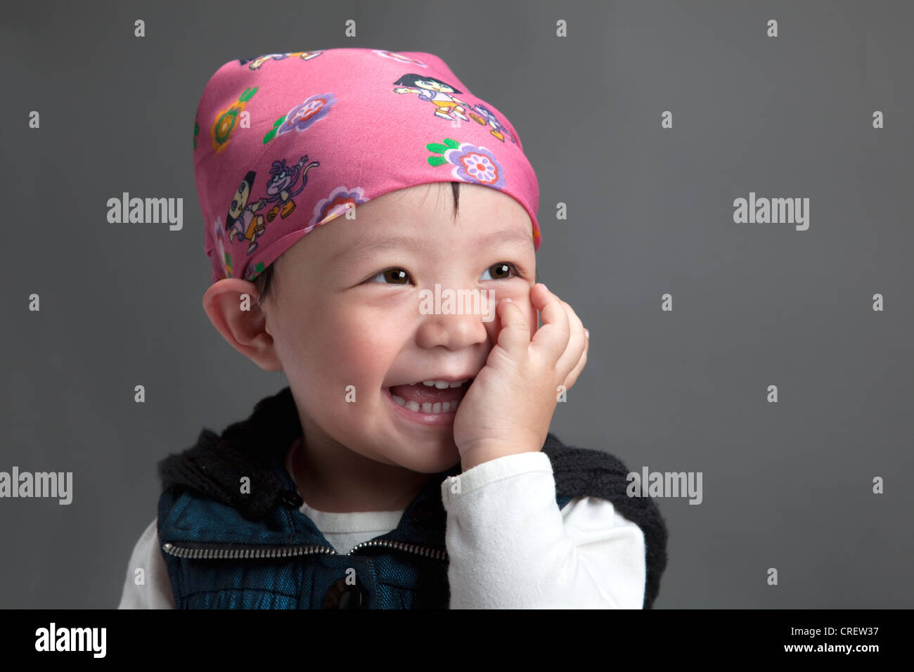 A 2 year old Chinese girl laughing excitedly with hand to face Stock ...