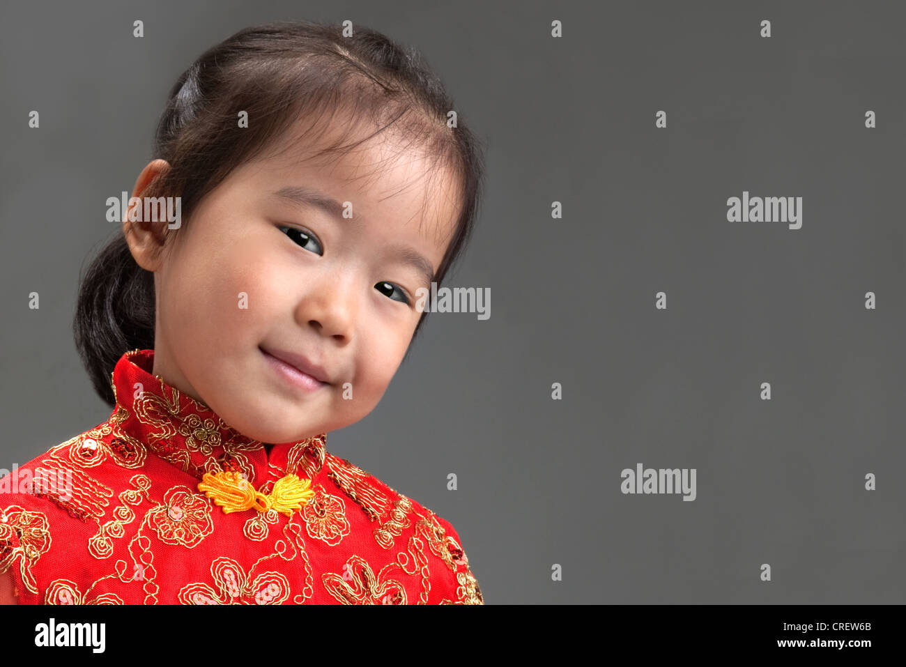 Head and shoulders portrait of a smiling 5 year old Chinese girl ...