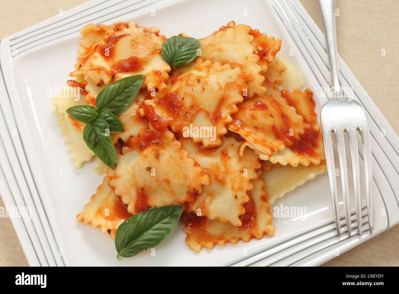 Three cheese ravioli in a pasta sauce with herbs close-up Stock Photo ...