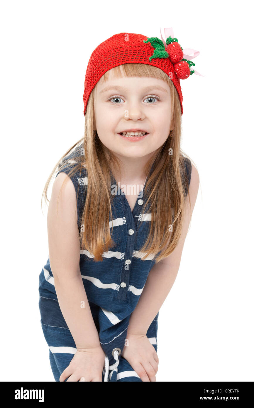 a charming little girl in the red cap looks into the camera. Isolate on ...