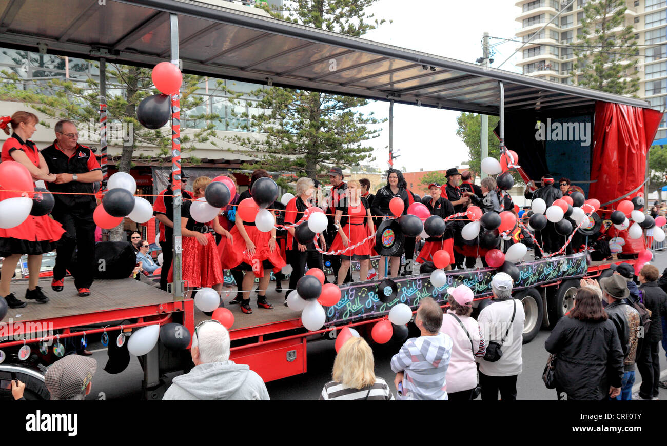 Crowds look at rock n rollers on a display parade truck at the 'Cooly ...
