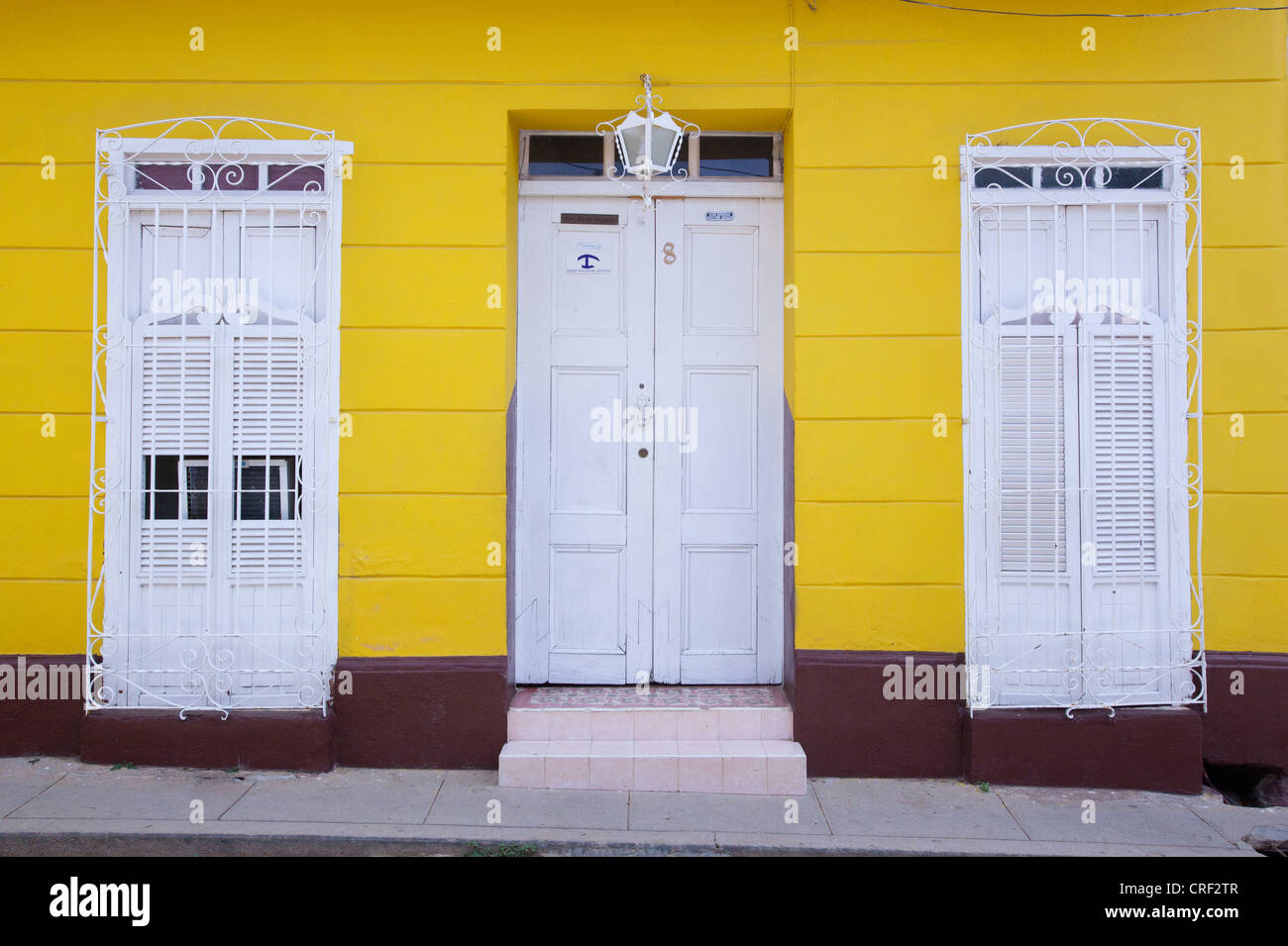 Bright yellow building with white door and white shutters in Trinidad ...