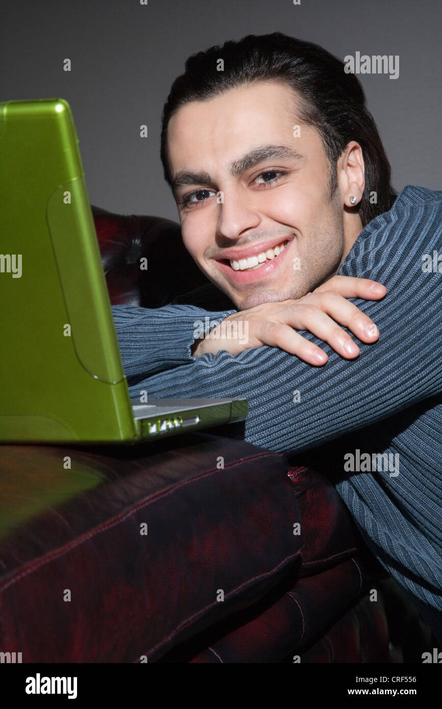 Portrait of cheerful young man using laptop Stock Photo - Alamy