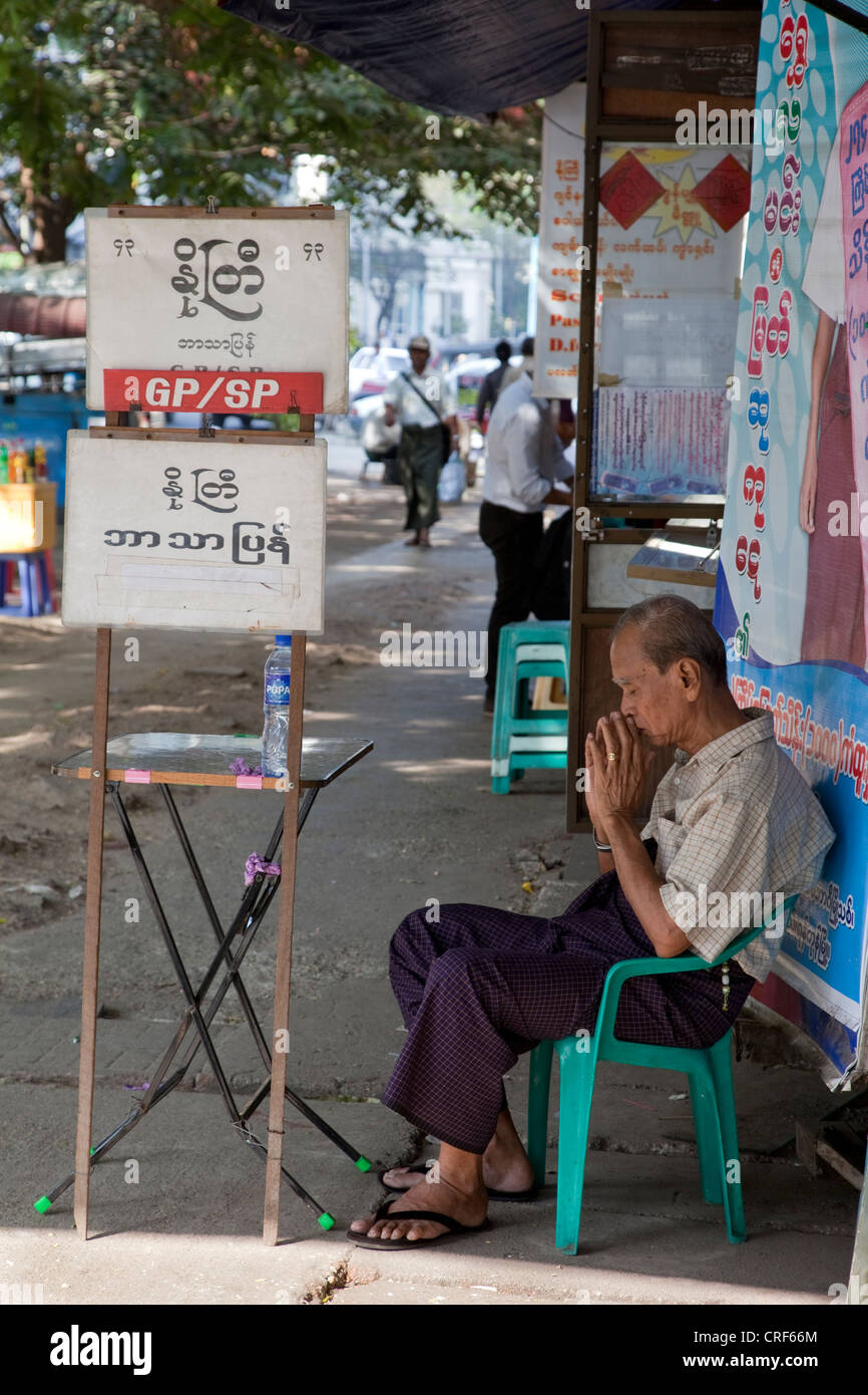 Myanmar, Burma, Yangon. Man Sitting, Dozing, Possibly Praying, on ...