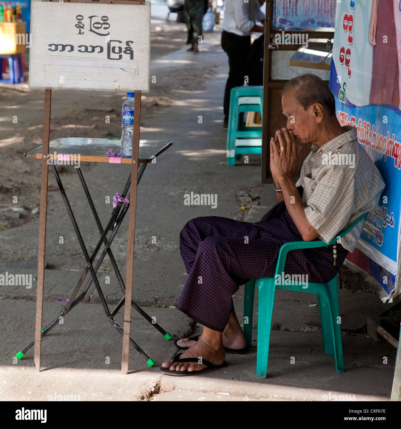 Myanmar, Burma, Yangon. Man Sitting, Dozing, Possibly Praying, on ...