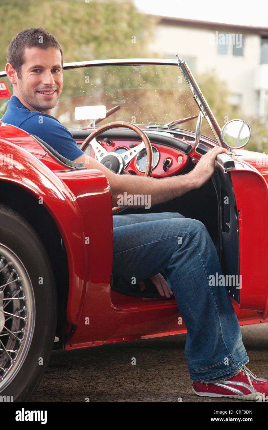 Portrait of a handsome young man in red car Stock Photo - Alamy