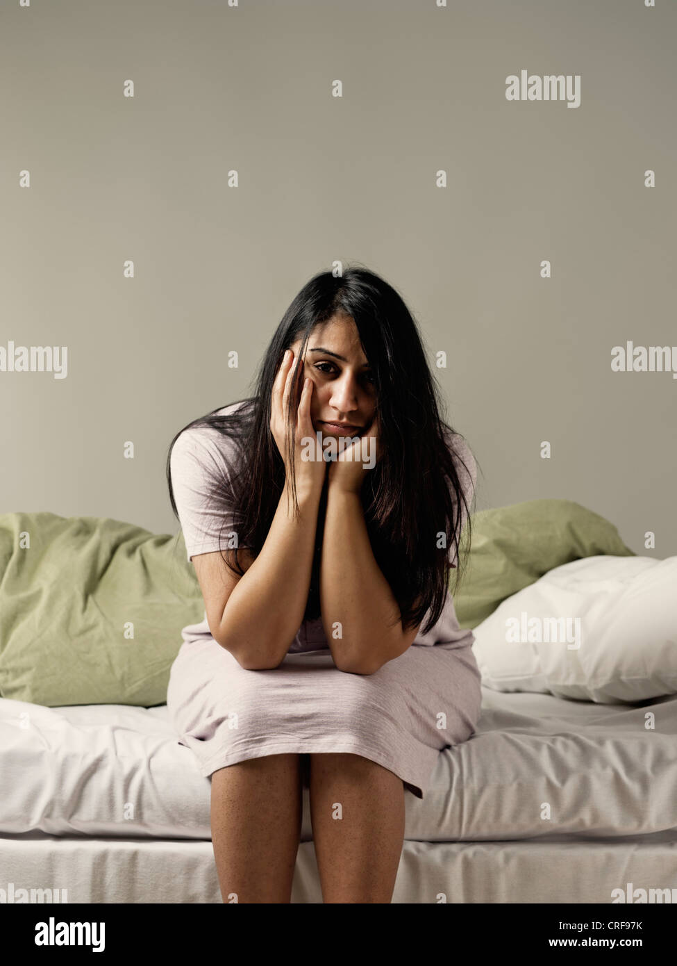 Depressed woman sitting on bed Stock Photo - Alamy