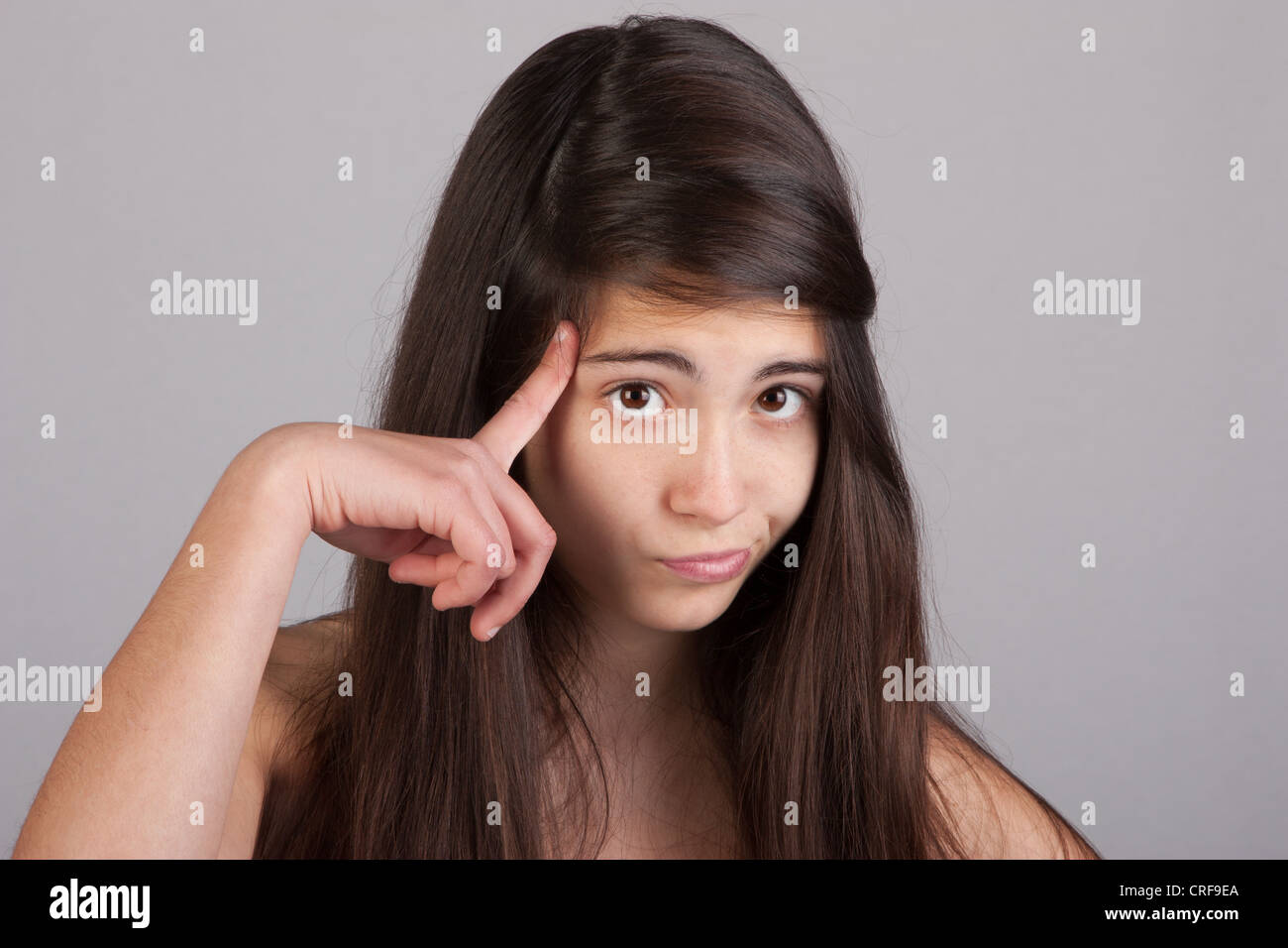 Smiling young female pointing to head Stock Photo - Alamy