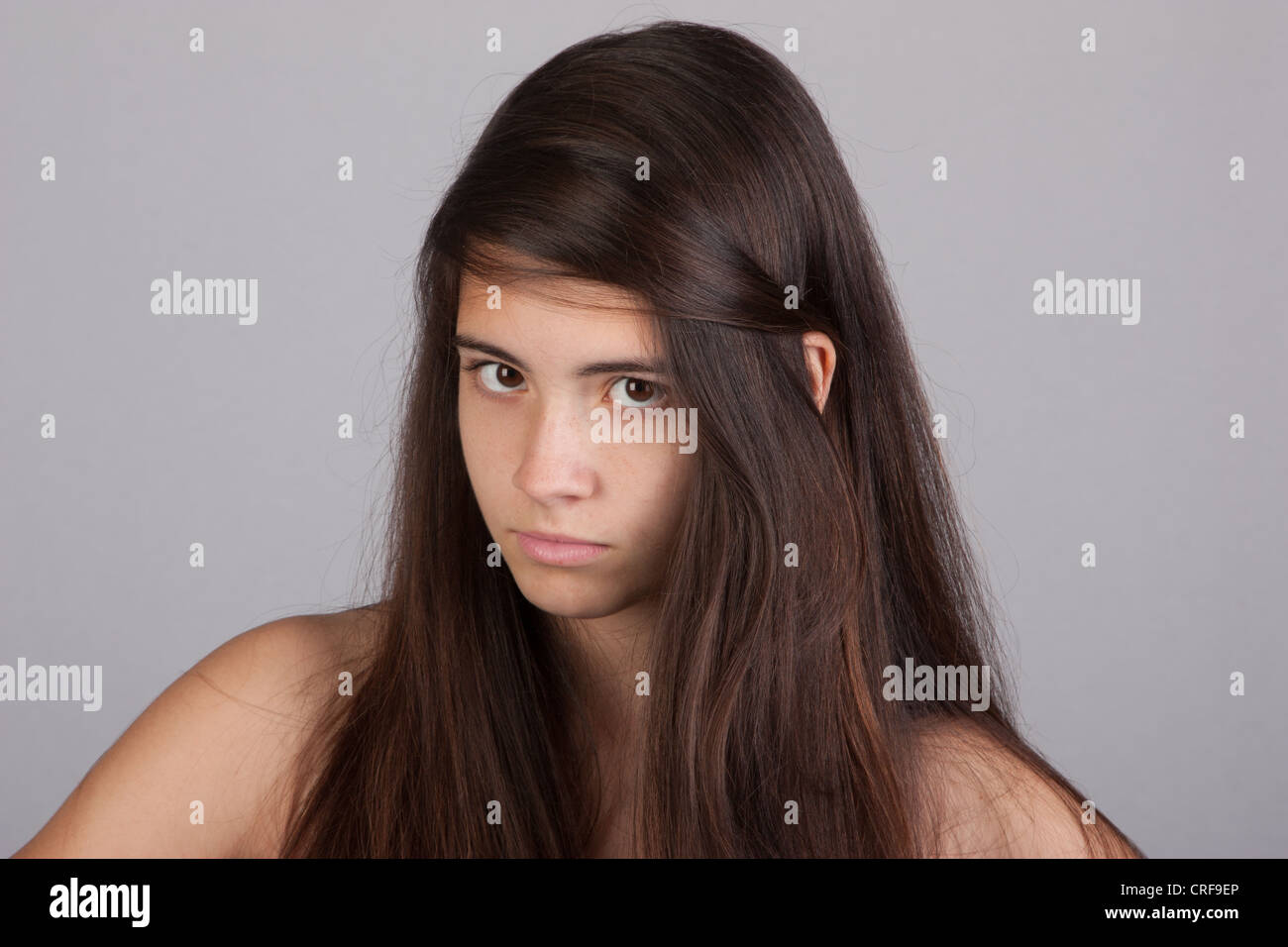Pretty woman looking angry over a grey background Stock Photo - Alamy