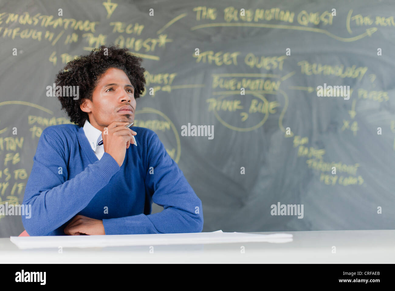 Student listening at desk in class Stock Photo - Alamy