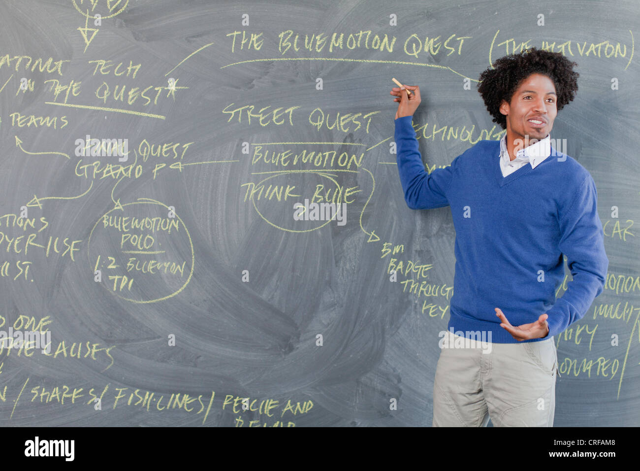 Teacher pointing to chalkboard Stock Photo - Alamy