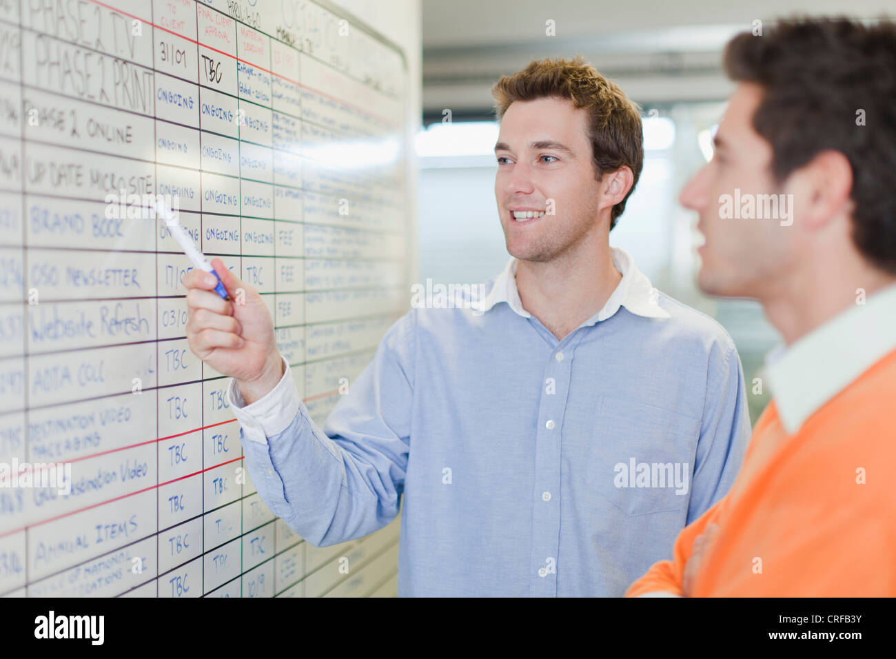 Businessman pointing to whiteboard Stock Photo - Alamy