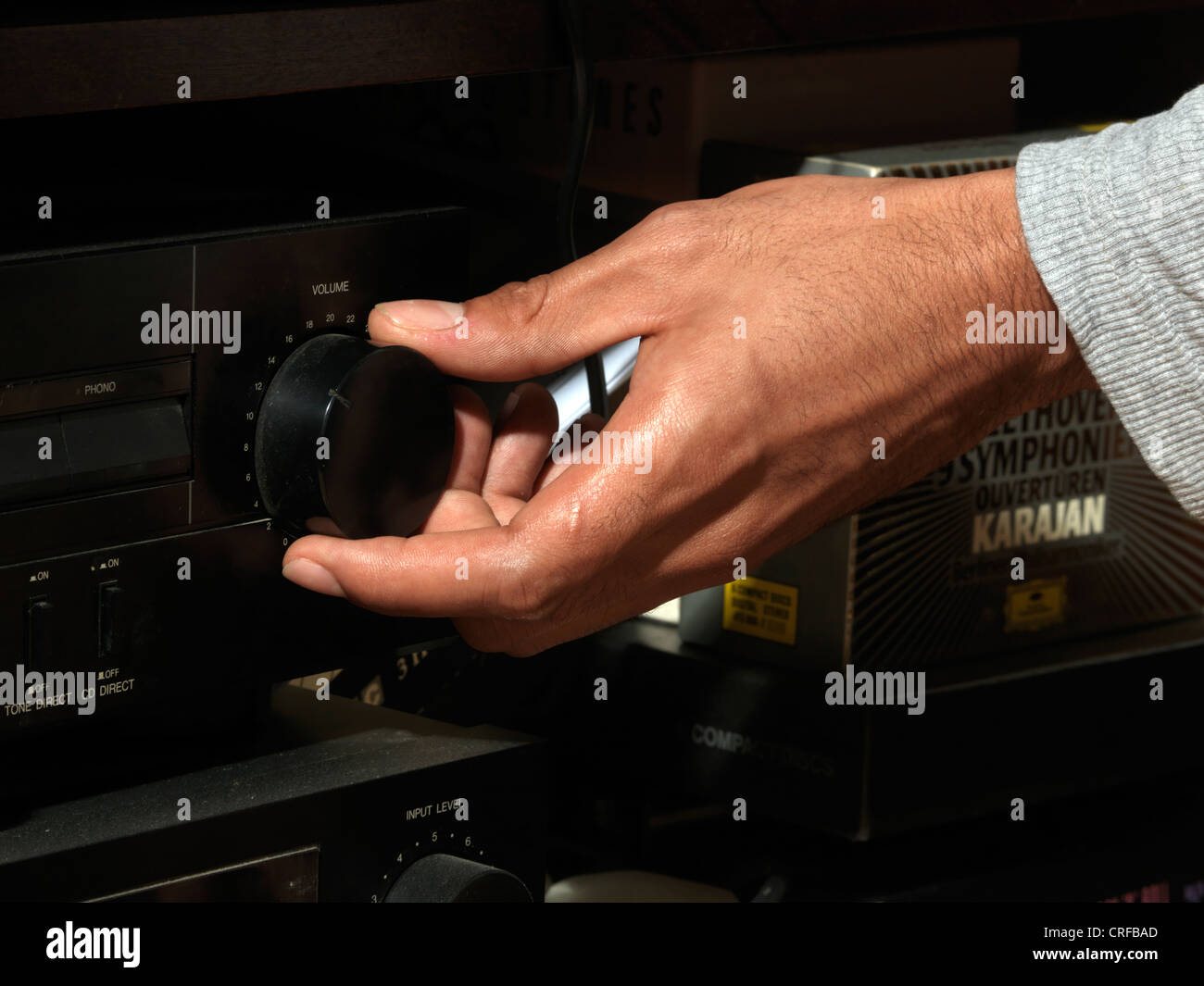 Afro-Caribbean Man's Hand Turning Volume Control Knob On A HI FI System ...