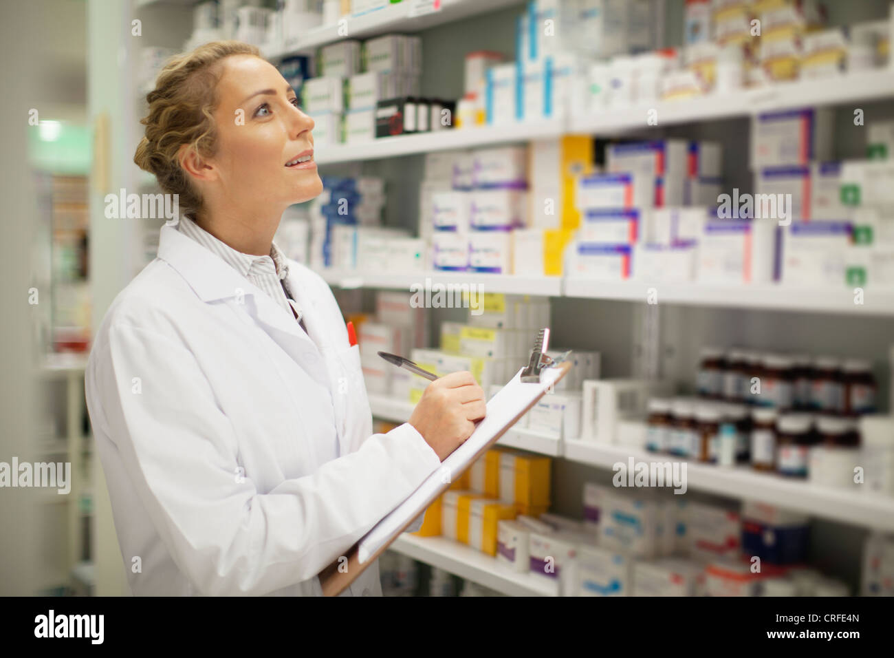 Pharmacist writing on clipboard Stock Photo - Alamy