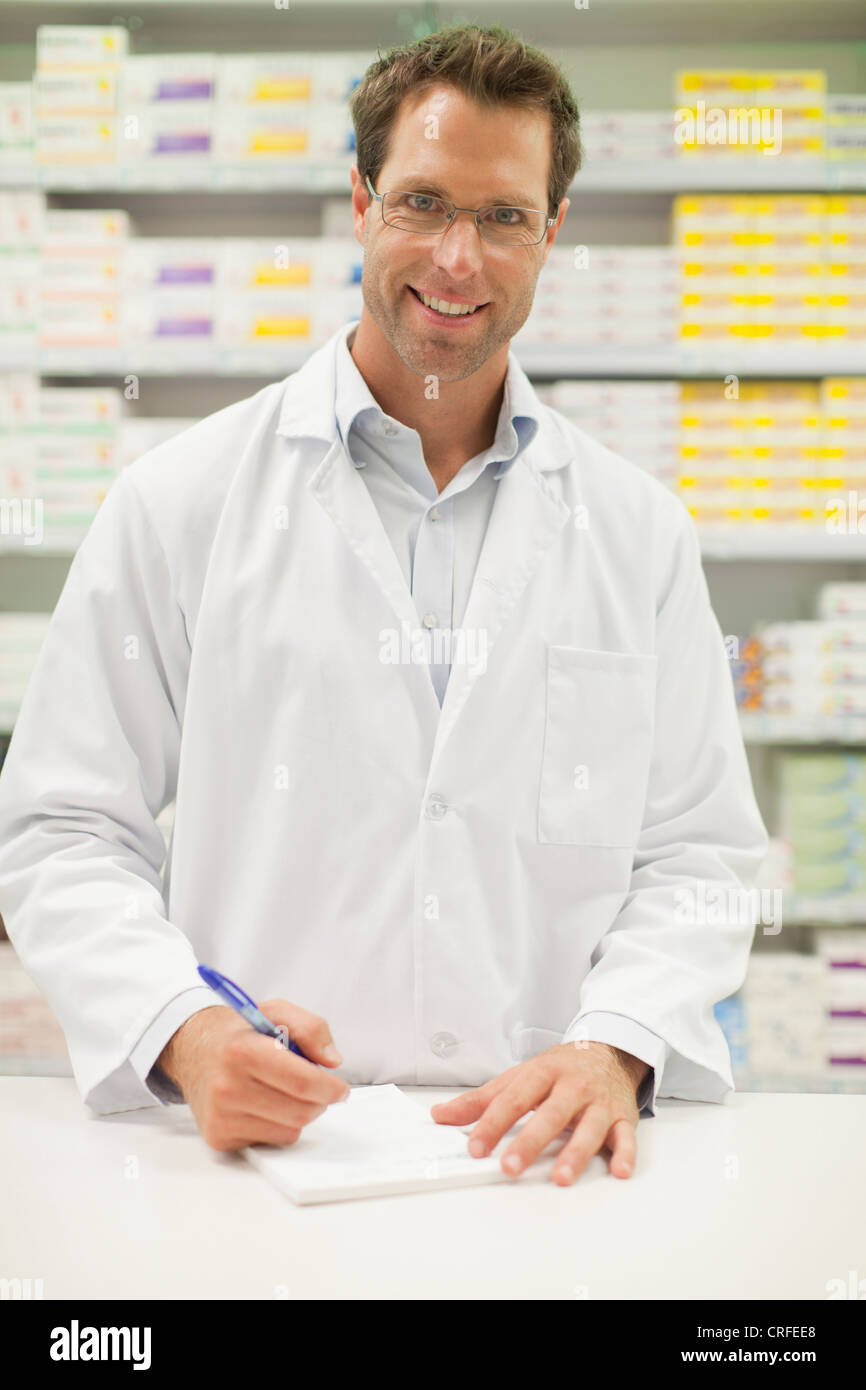 Pharmacist making notes at counter Stock Photo - Alamy