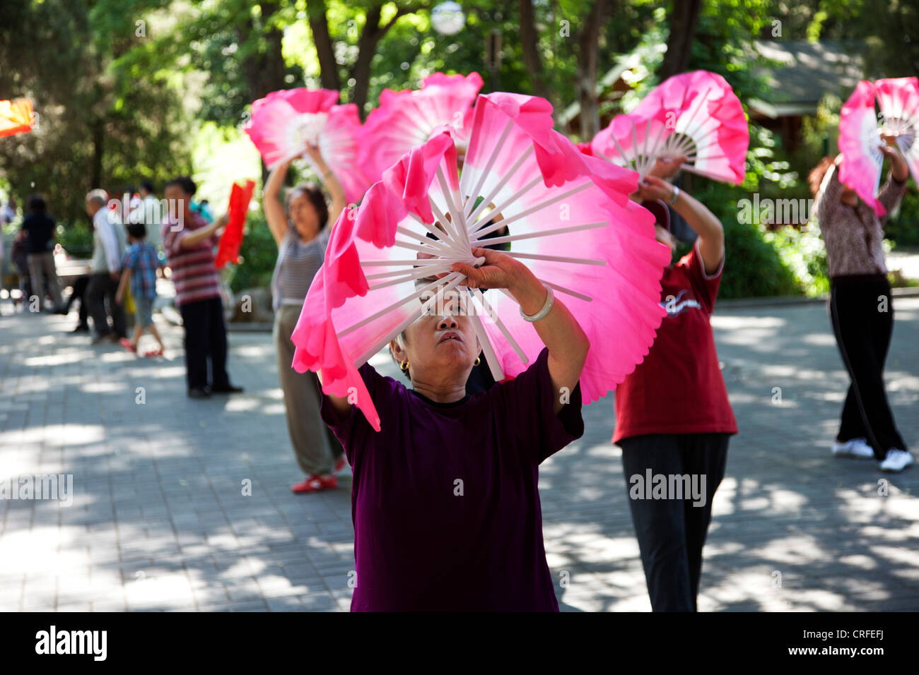 People take their morning exercise, fan dancing, in Zizhuyuan Park ...