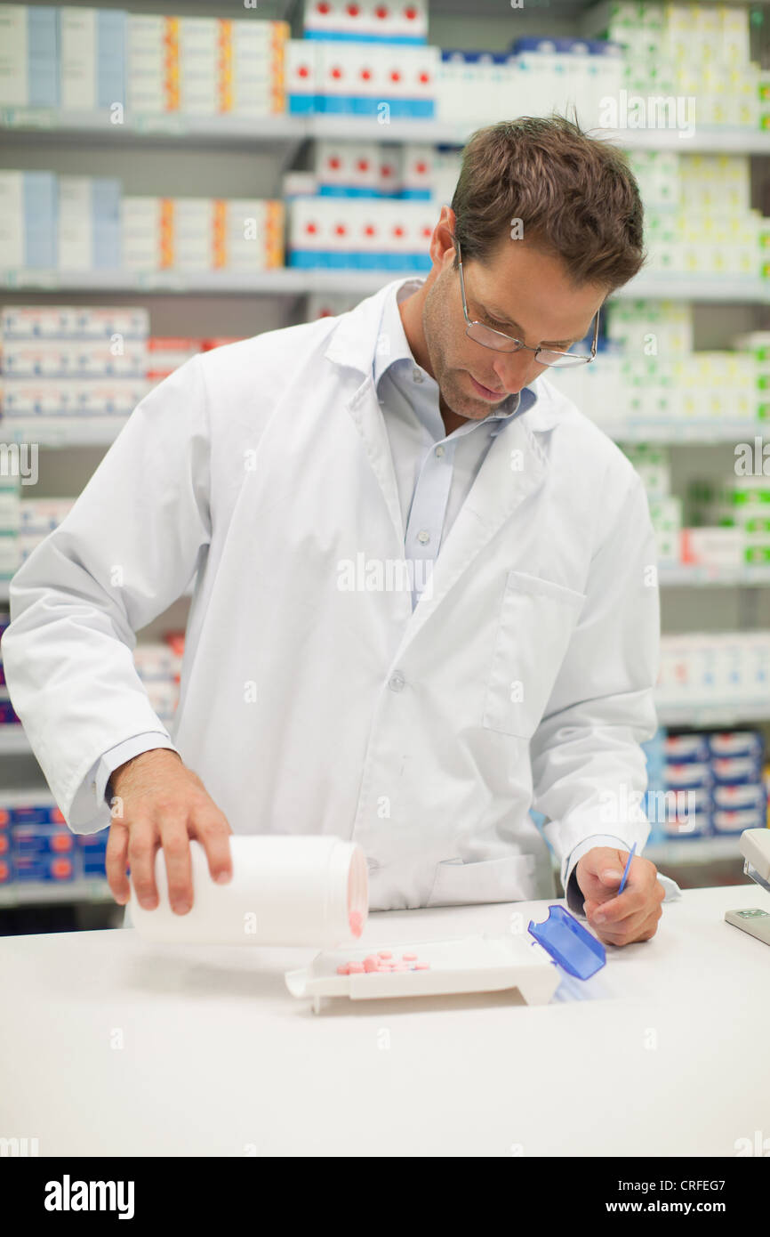 Pharmacist counting pills at counter Stock Photo - Alamy