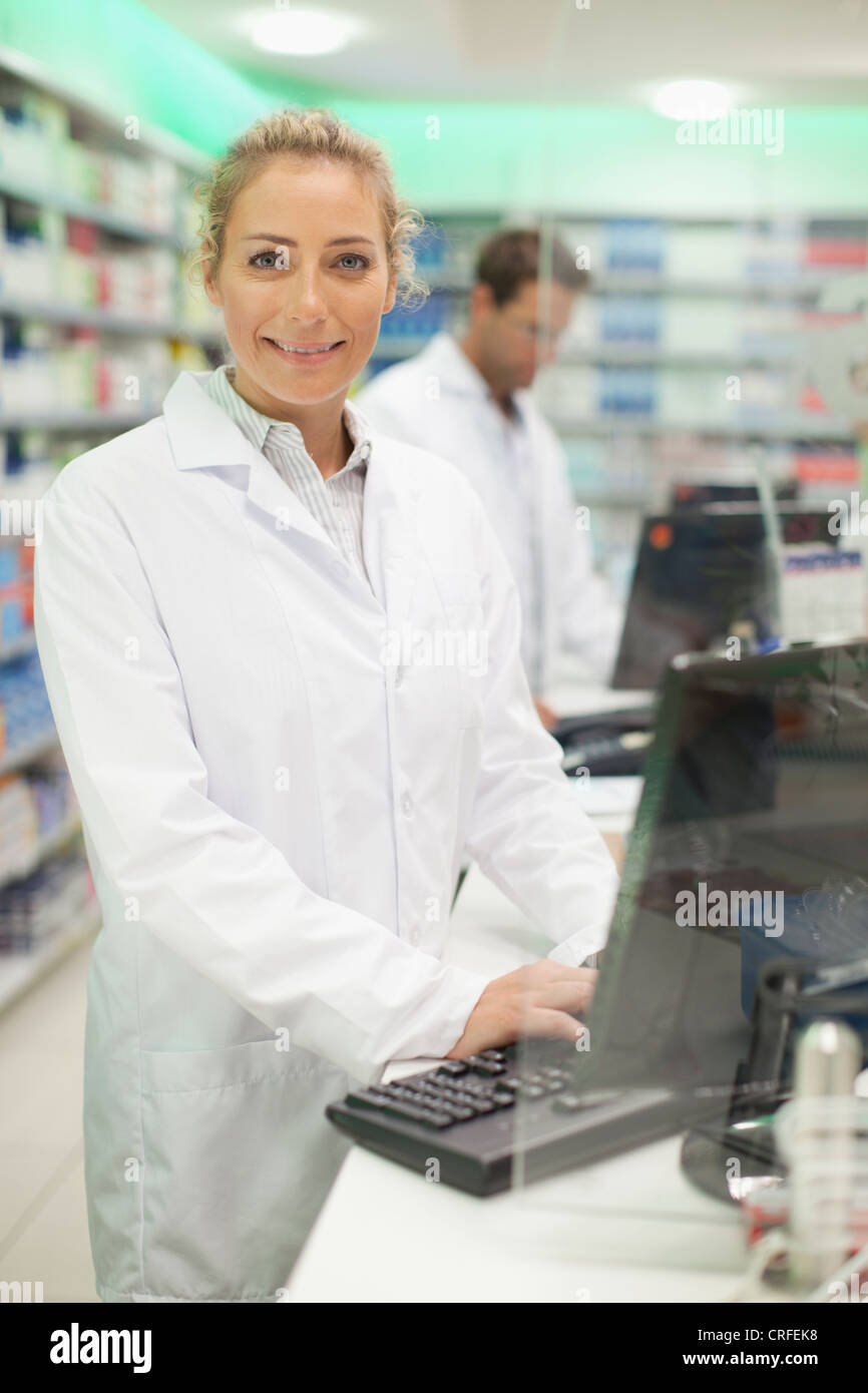 Pharmacist using computer at counter Stock Photo - Alamy