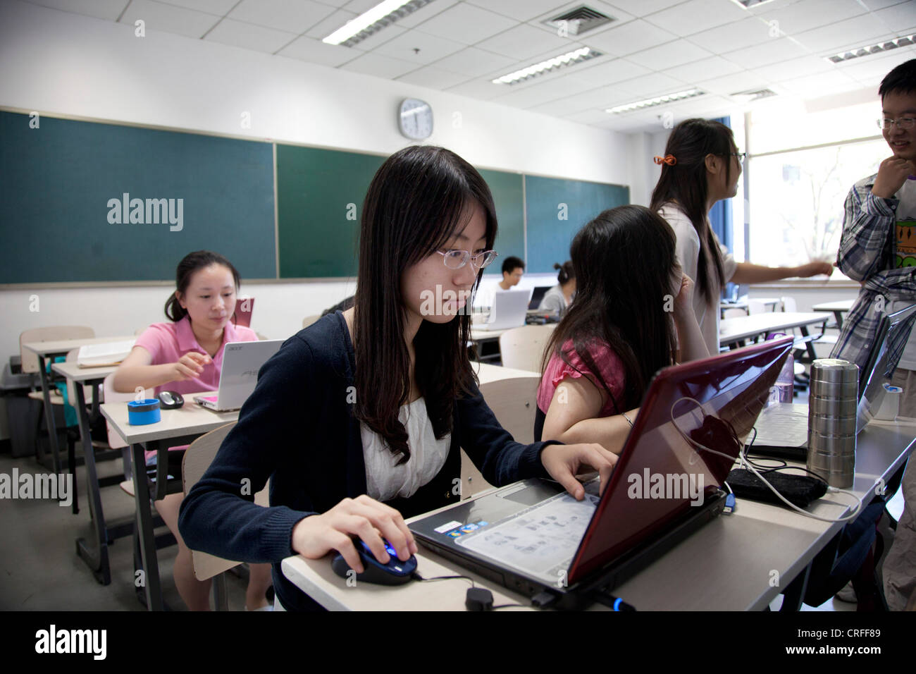 Student working on a laptop in a classroom on campus at Tsinghua ...