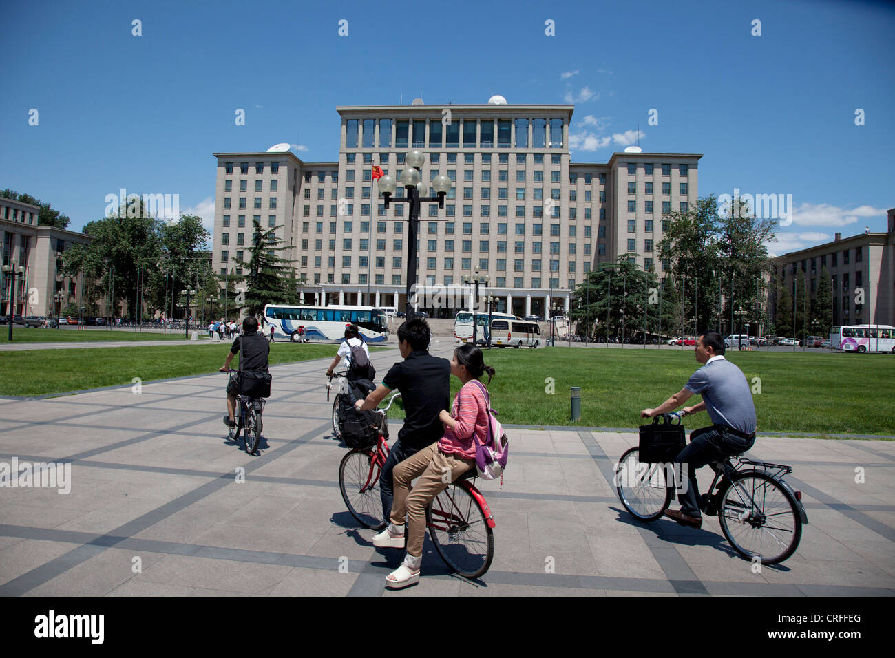 Students cycling past the central main building on campus at Tsinghua ...