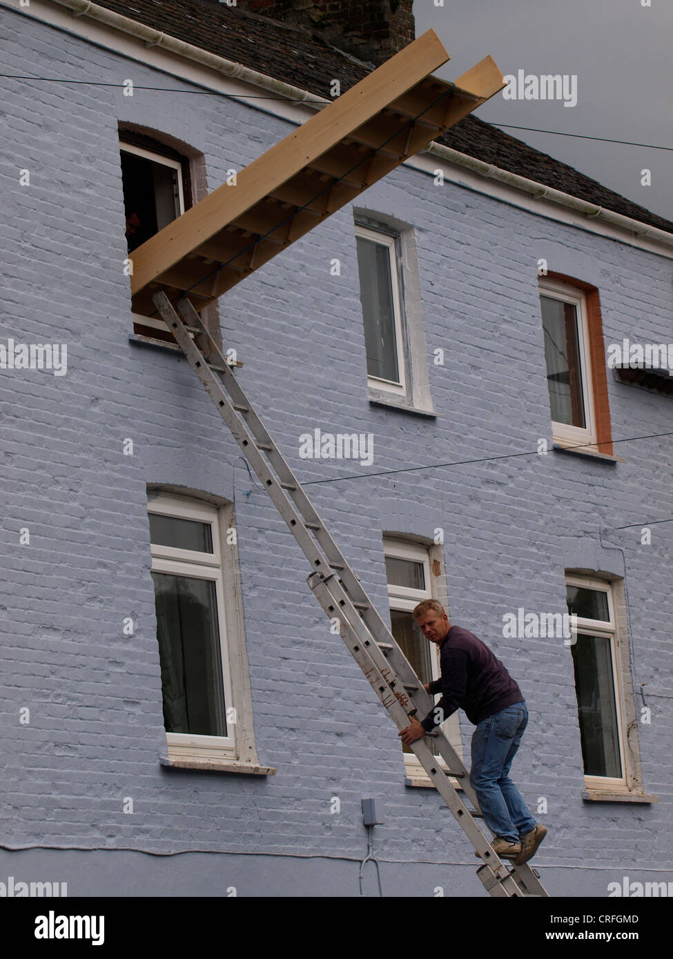 Builders getting a staircase into a house through the upstairs window ...