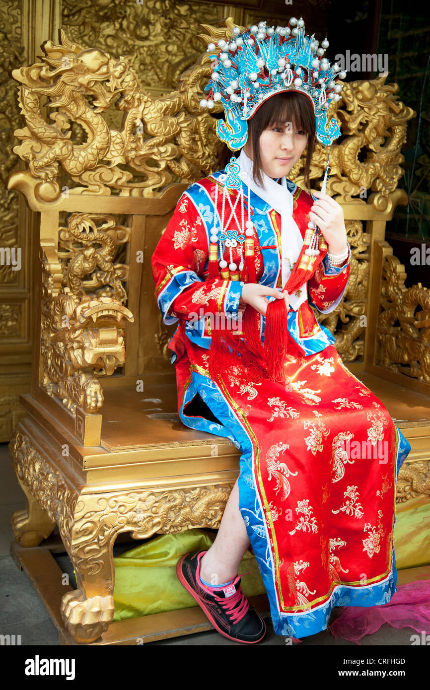 Girl sitting in a golden throne has her photo taken wearing traditional ...