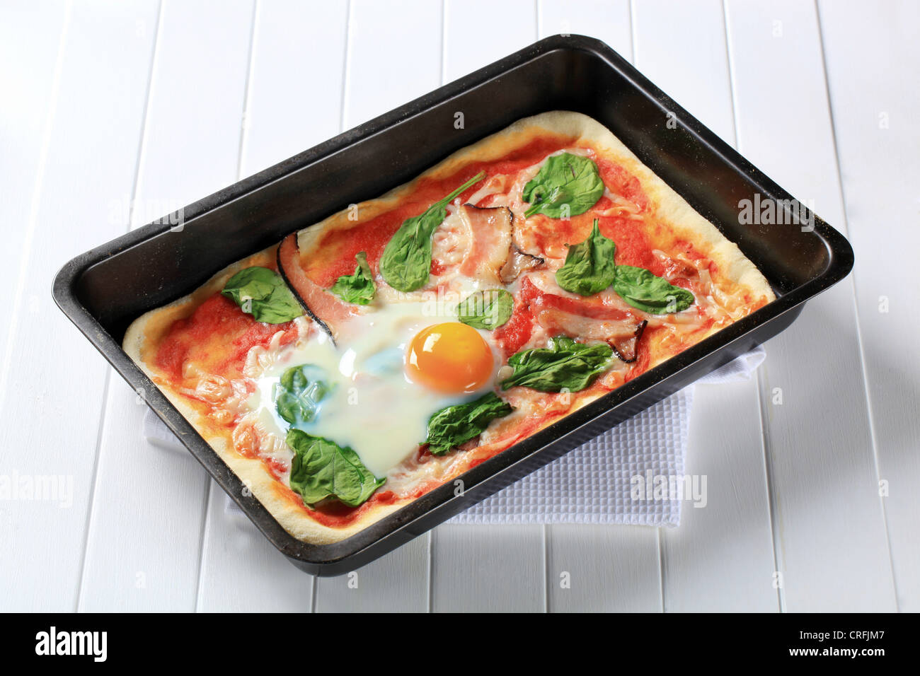 Bacon and egg pizza baked in a rectangular tray Stock Photo - Alamy