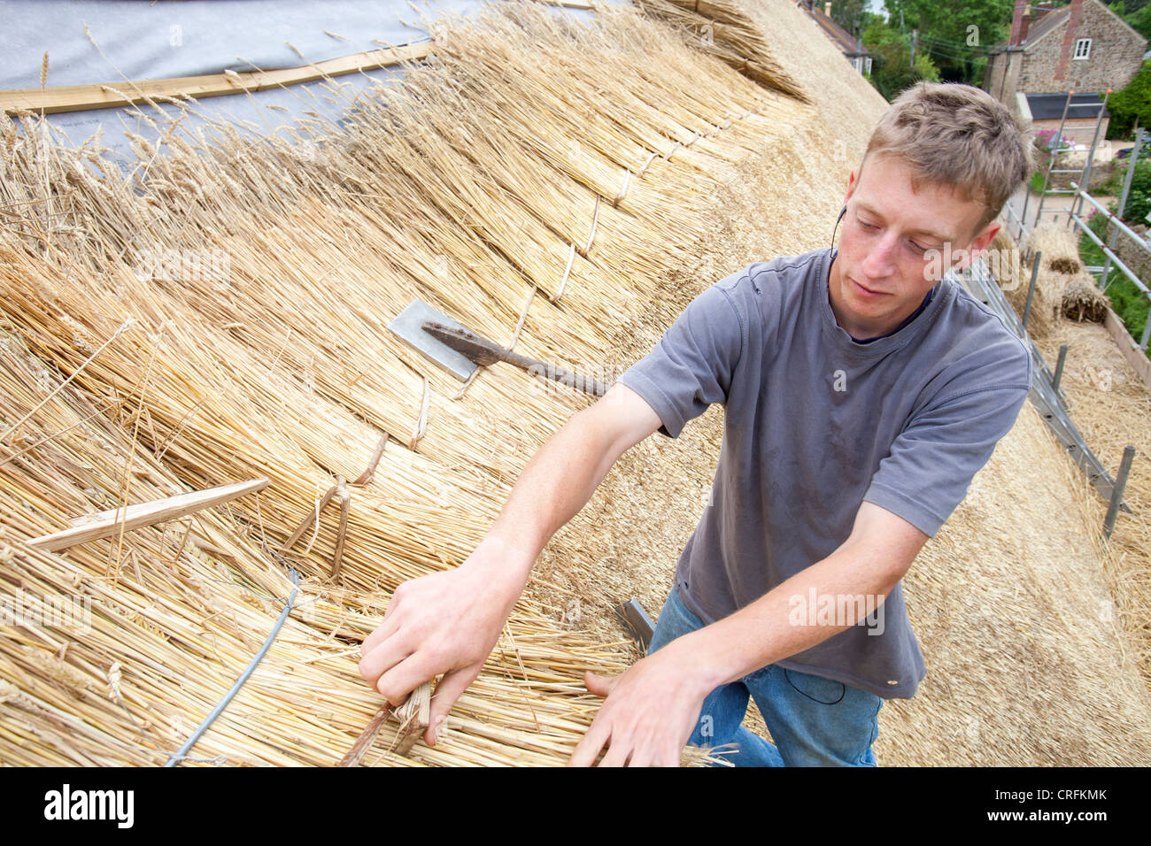 A skilled thatcher thatching a barn roof in Dorset, UK Stock Photo - Alamy