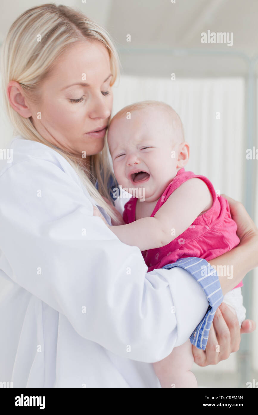 Doctor hugging crying baby Stock Photo - Alamy