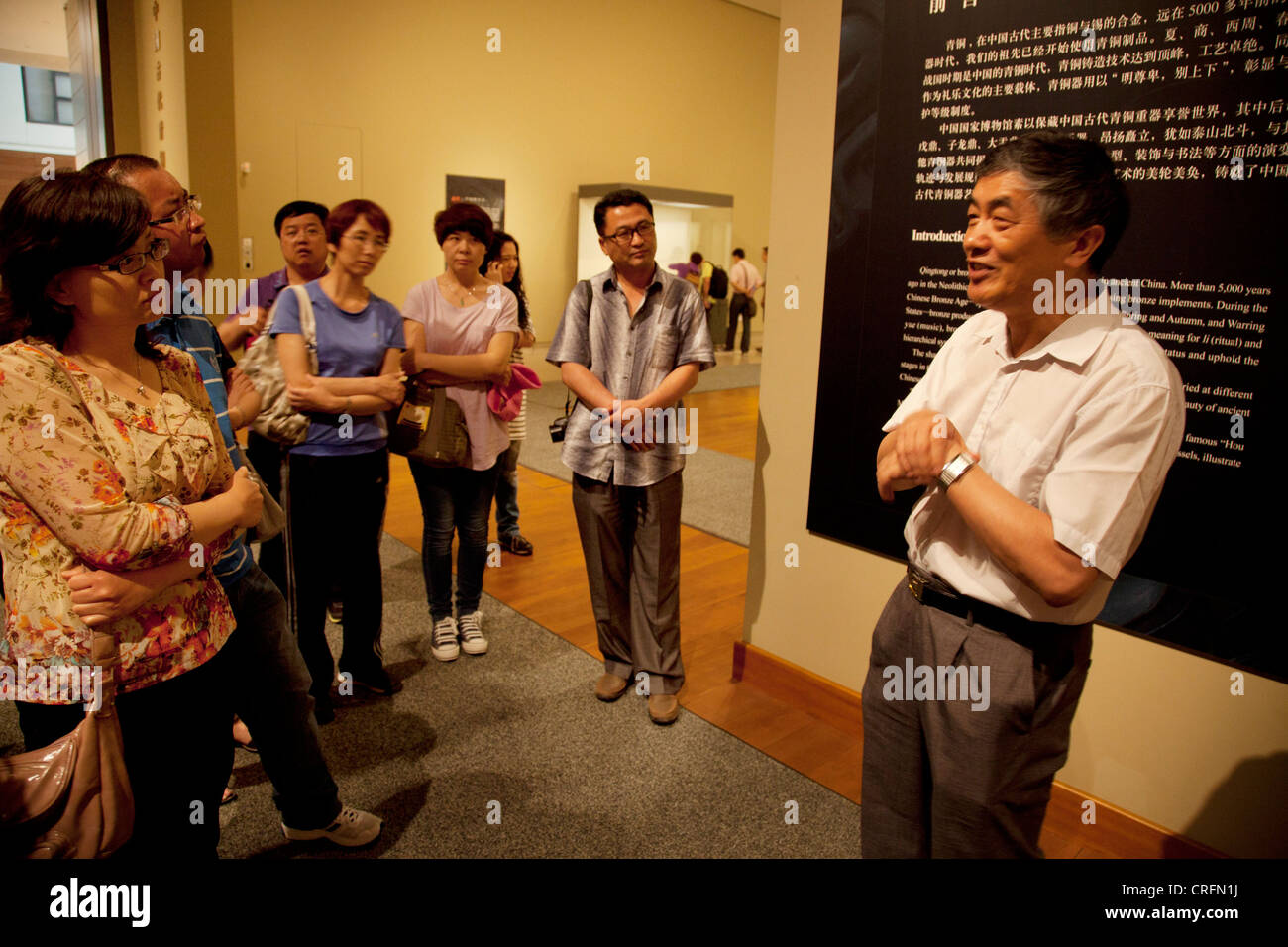 Tour guide speaks to tourists about Ancient Chinese art on show in an ...