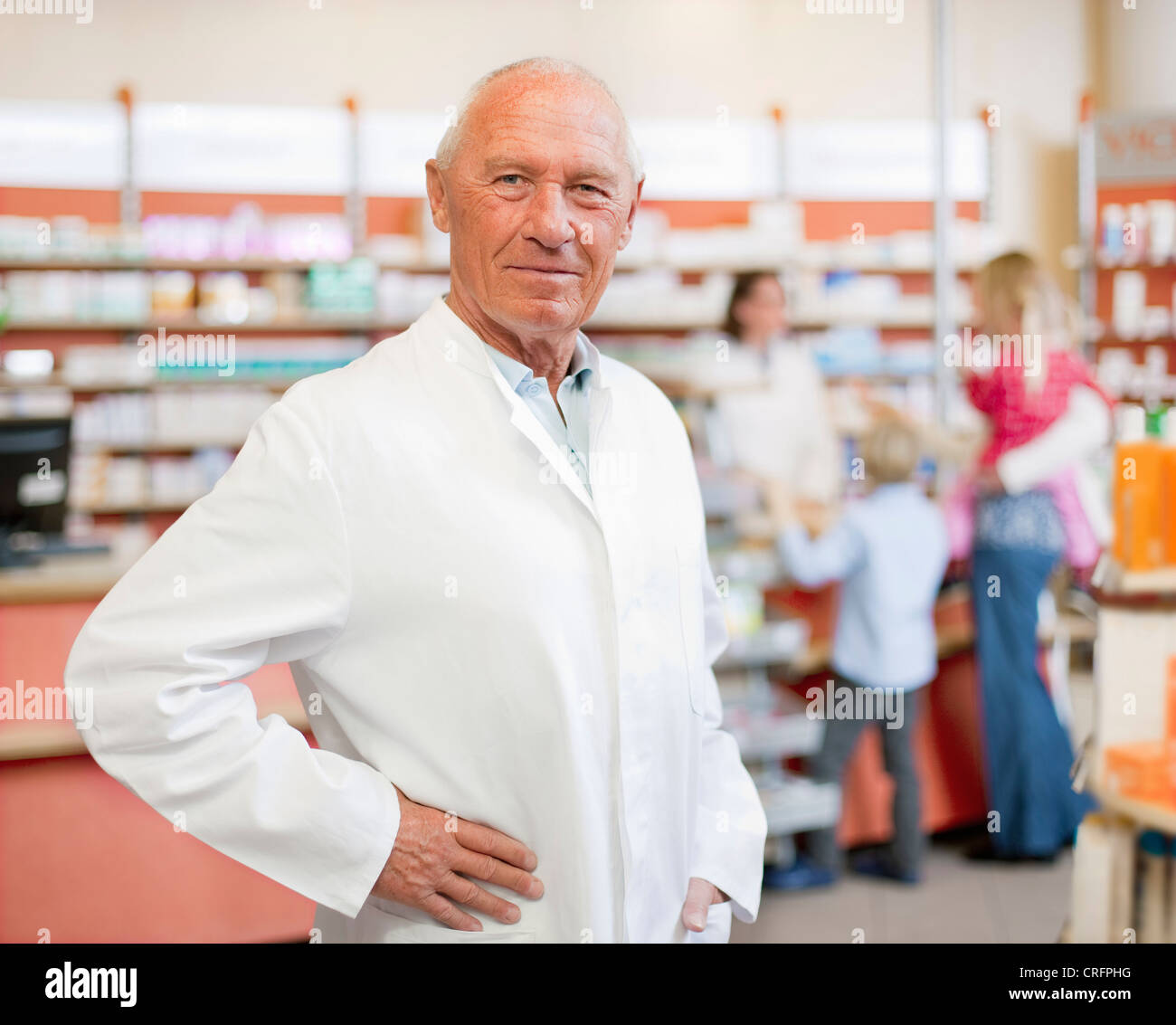 Smiling pharmacist standing in store Stock Photo - Alamy