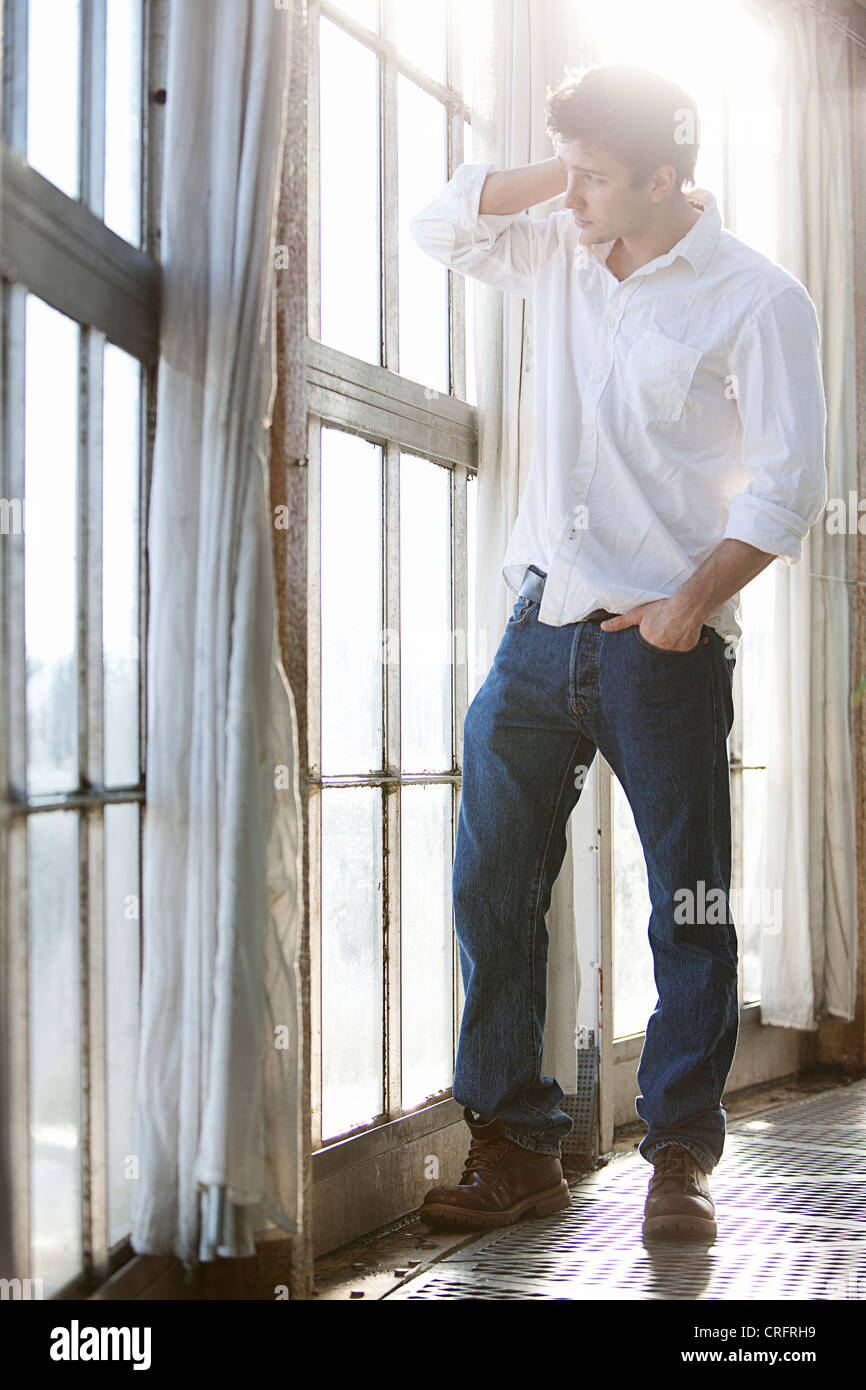 Man standing at window Stock Photo - Alamy