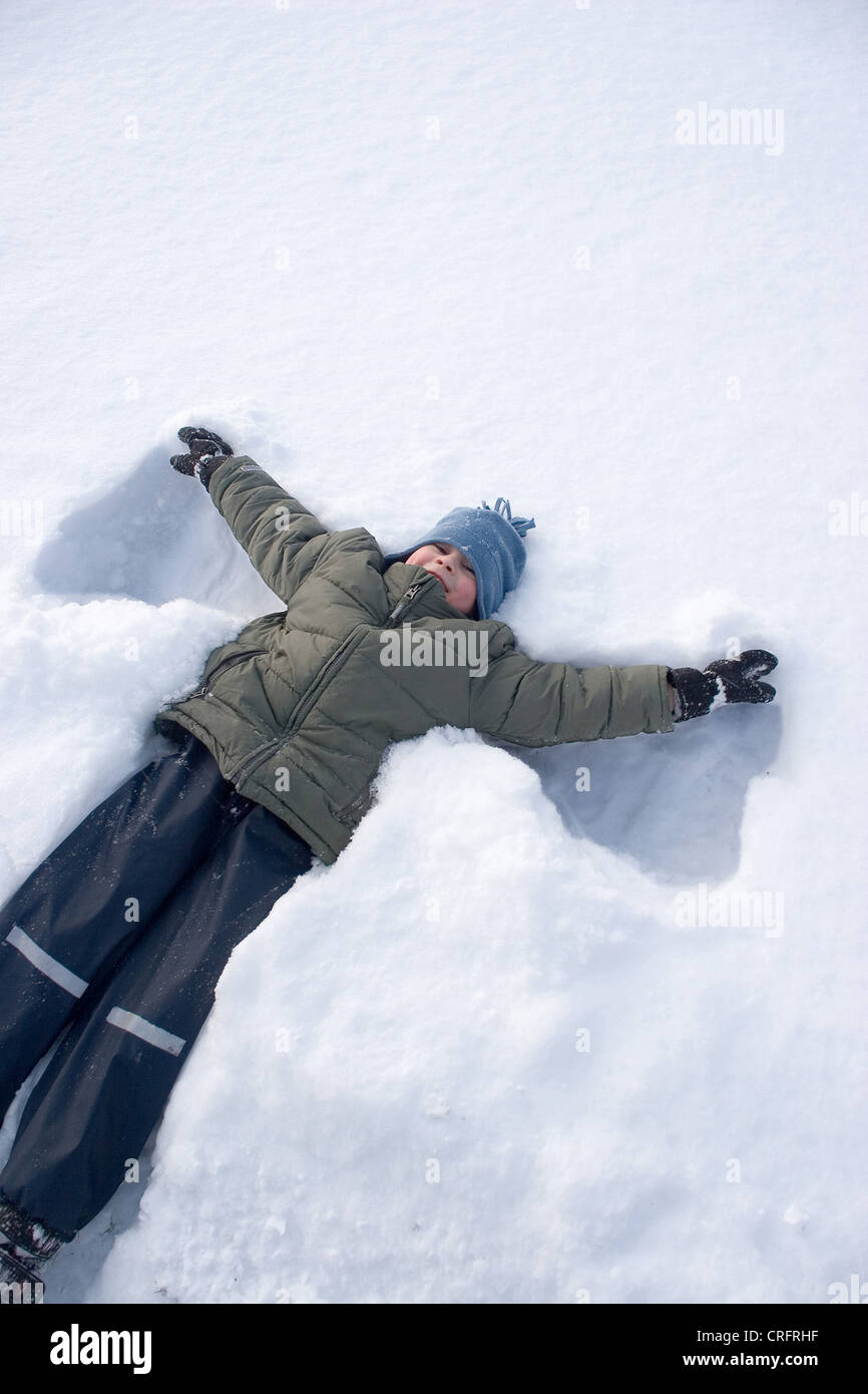 boy forming a snow angel Stock Photo - Alamy