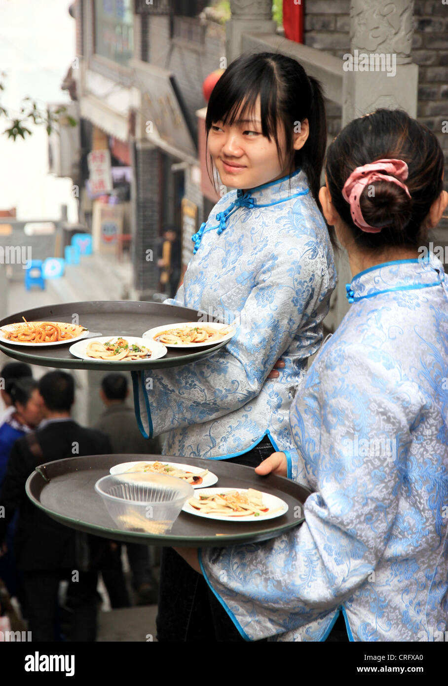 Two Chinese servers carrying food in Chongqing Stock Photo - Alamy