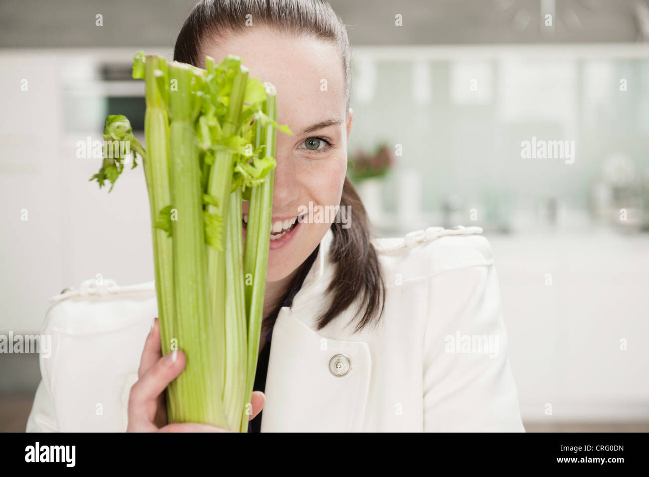 Smiling woman holding head of celery Stock Photo - Alamy