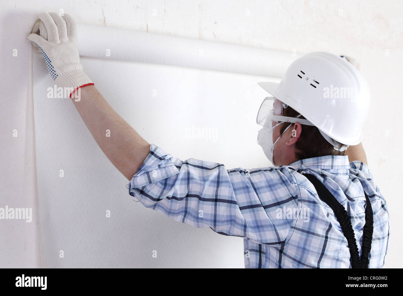 worker attaching wallpaper to wall Stock Photo - Alamy