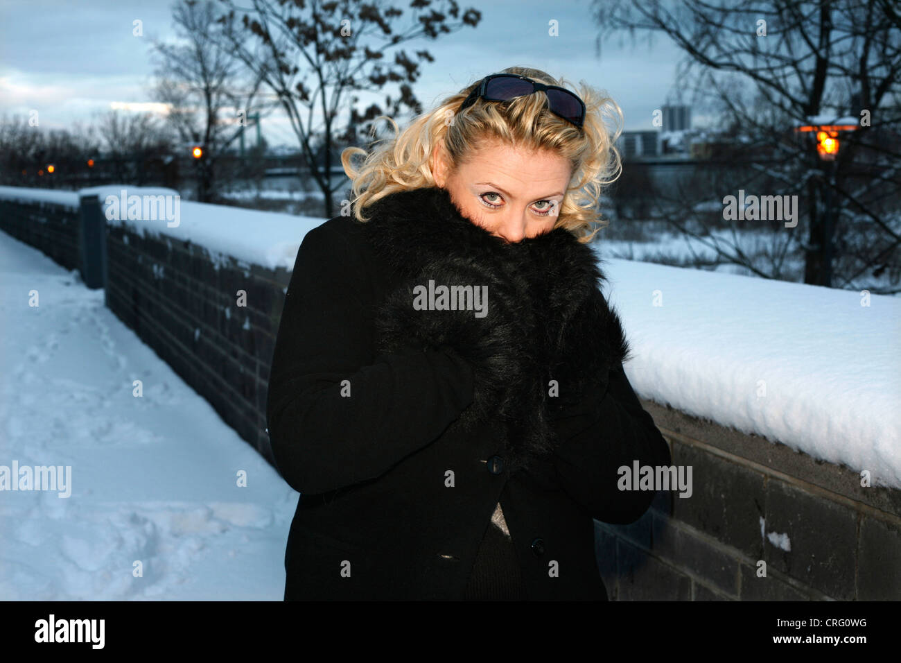 blond woman in black coat freezing on a cold winter day Stock Photo - Alamy